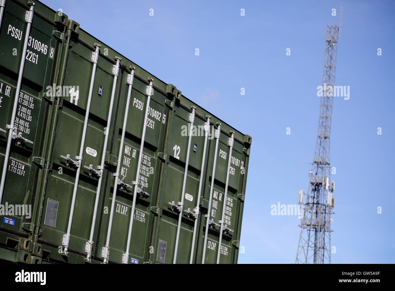 Shipping containers in a yard with a telecommunications tower in the ...