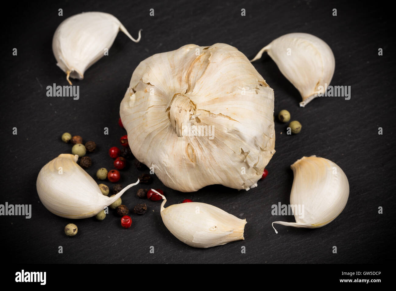 still life photo of organic whole garlic on black stone plate Stock ...