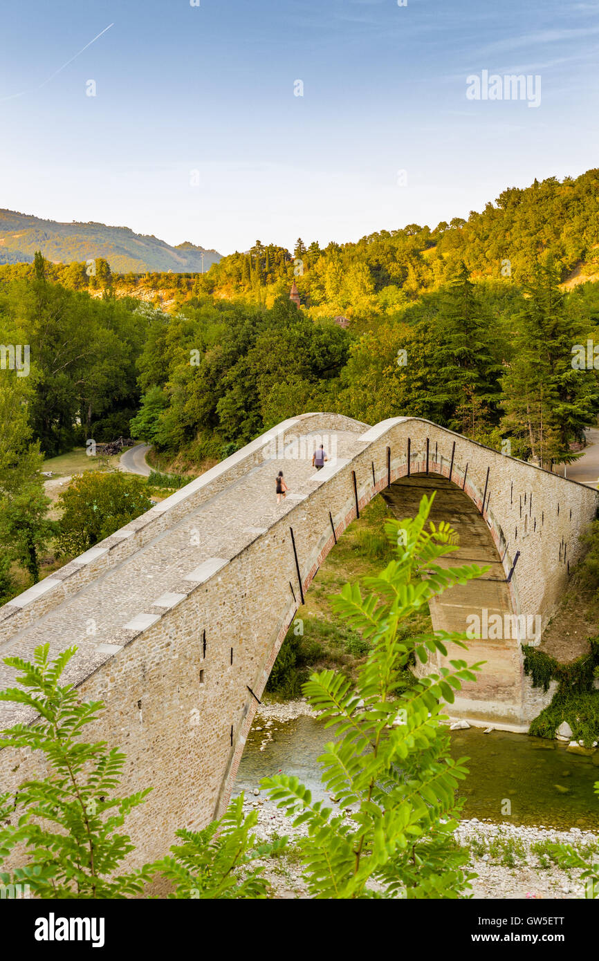 engaged couple crossing ancient hunchback bridge in Emilia Romagna ...