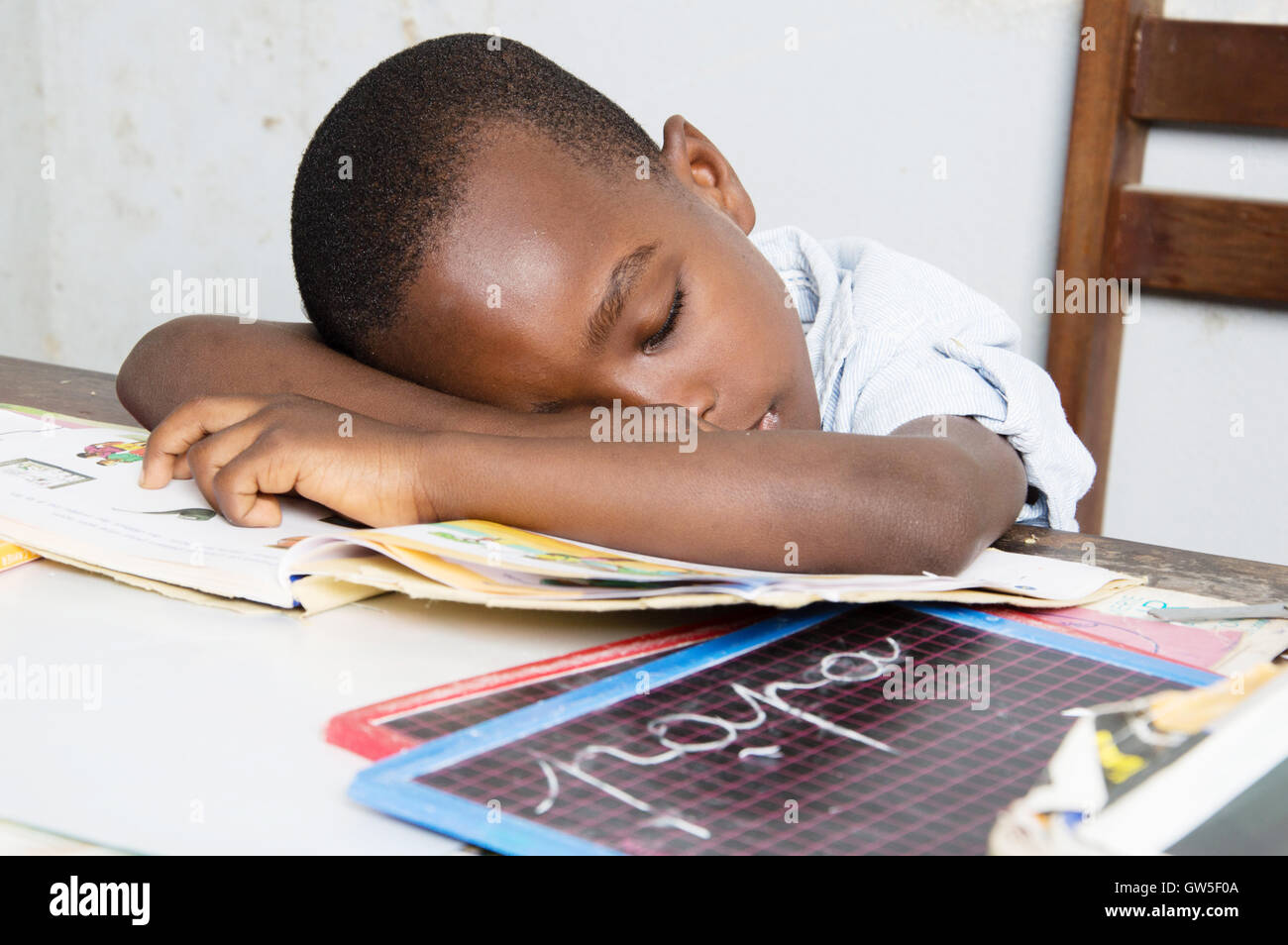 child tired of studying , sleeping on his study table with his head in ...