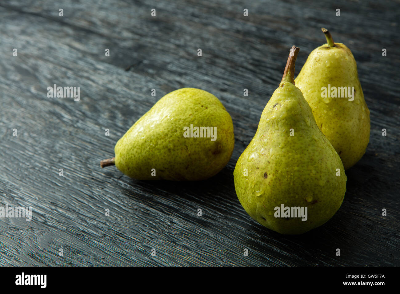 Three green pear on a black background Stock Photo - Alamy