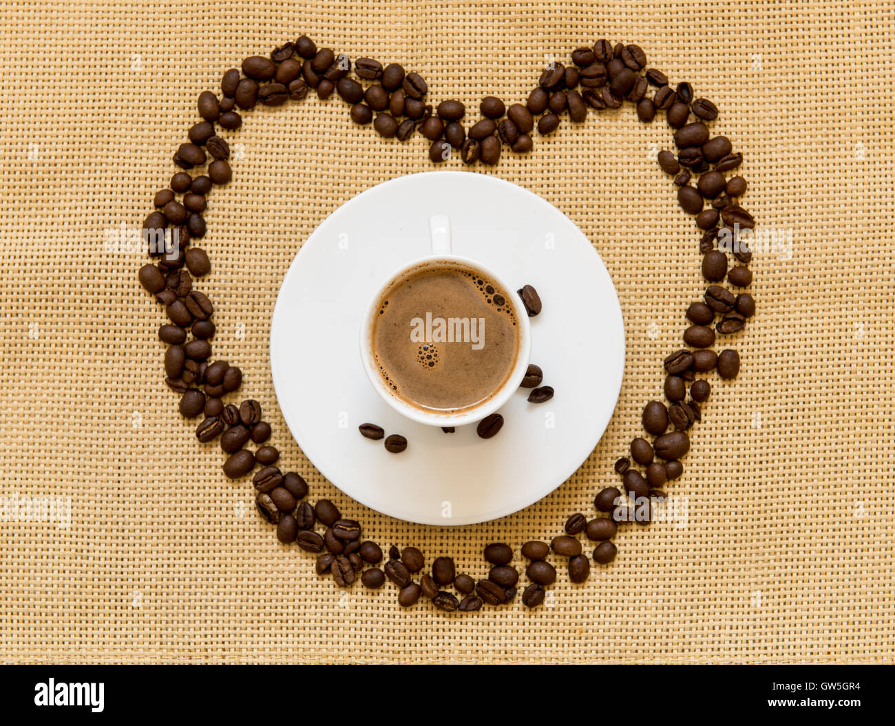 Coffee beans in the shape of heart symbol and a cup of black espresso ...