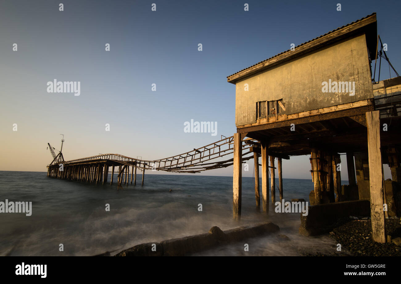 Seascape with old deserted industrial jetty during sunset at ...