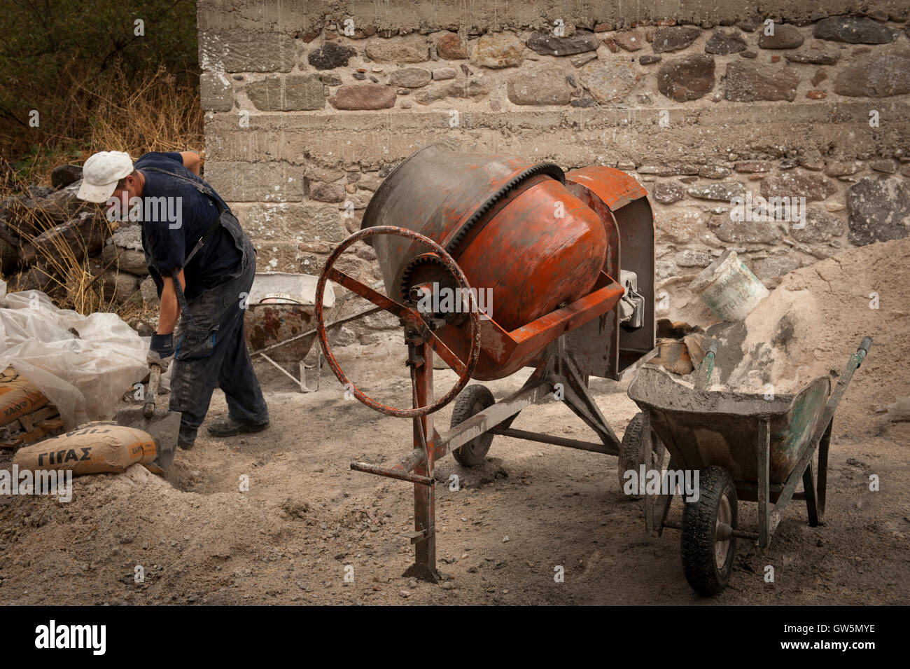 Albanian worker mixes cement for a construction job repairing a wall in ...