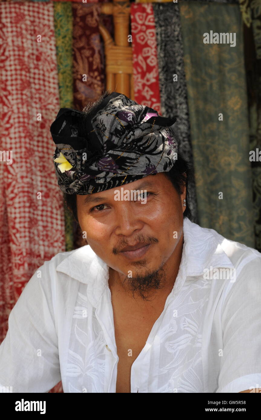 Balinese man with head scarf selling batik sarongs, Ubud, Bali ...