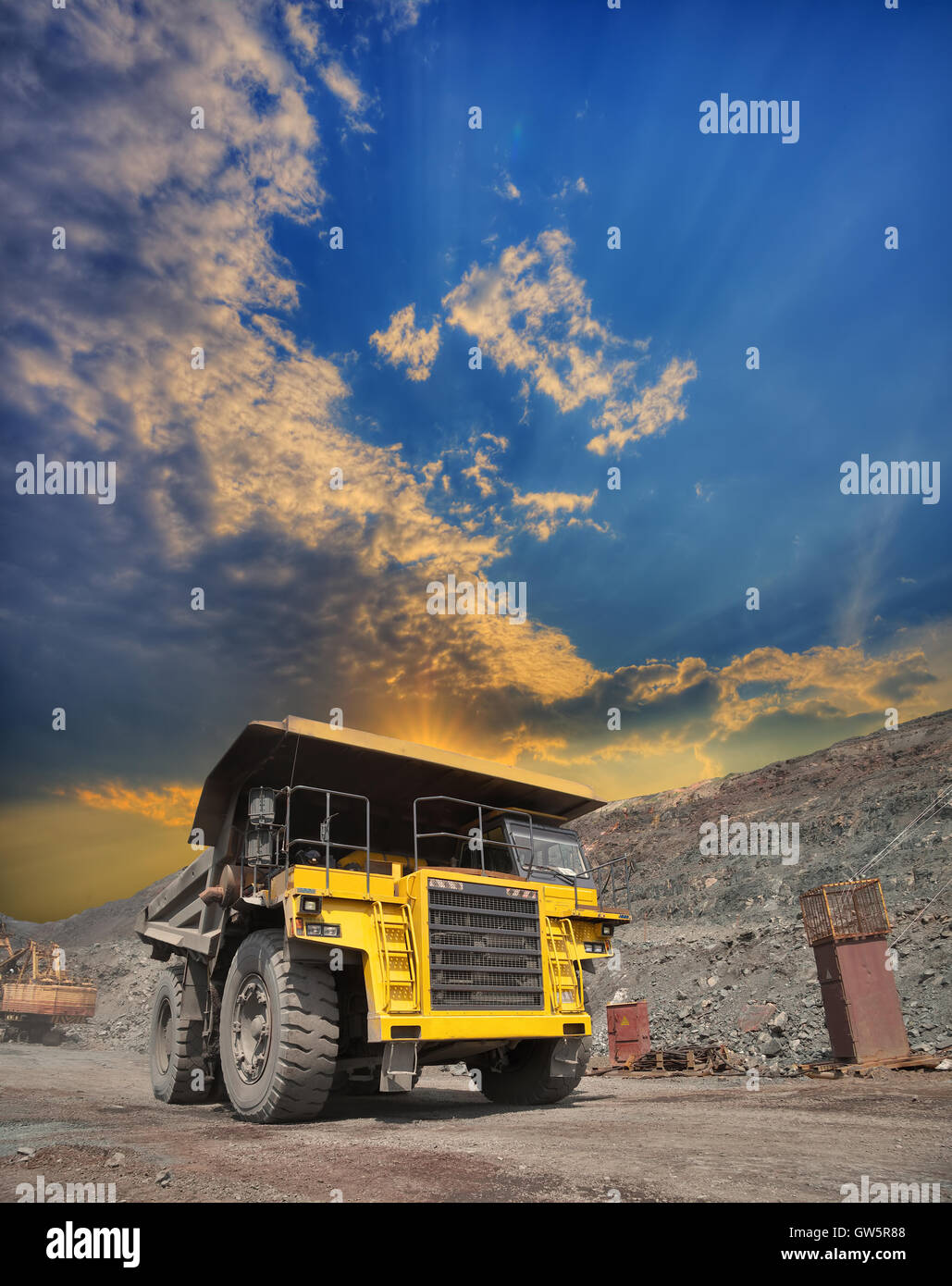 Mining truck loaded withiron ore driving along the opencast on sunset ...