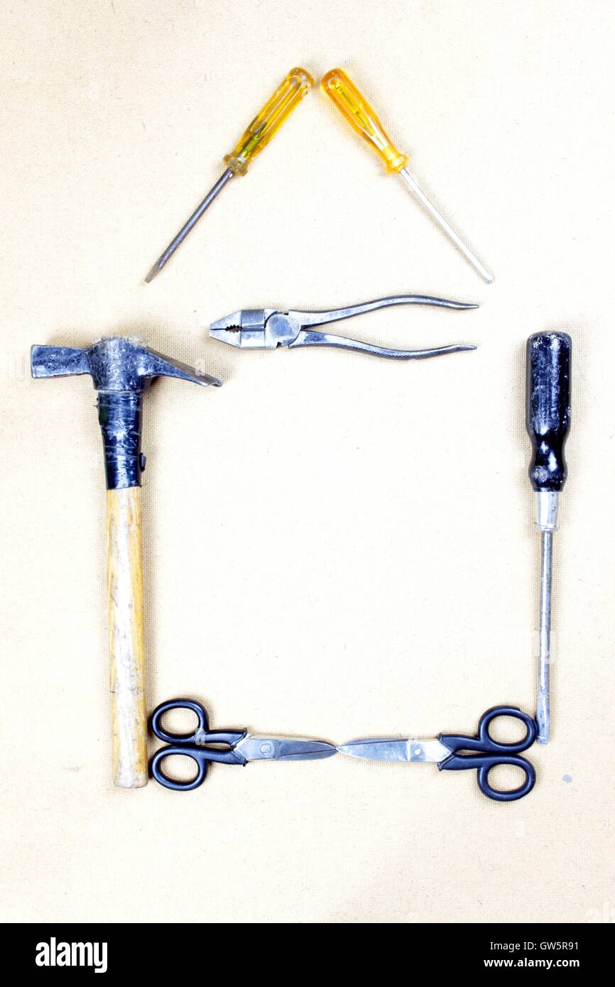 Image of tools in shape of house. Background with a brown wood panel ...