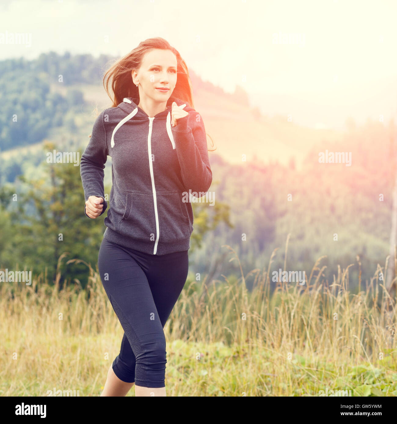 Young fitness woman trail running in mountains. Pretty caucasian girl ...
