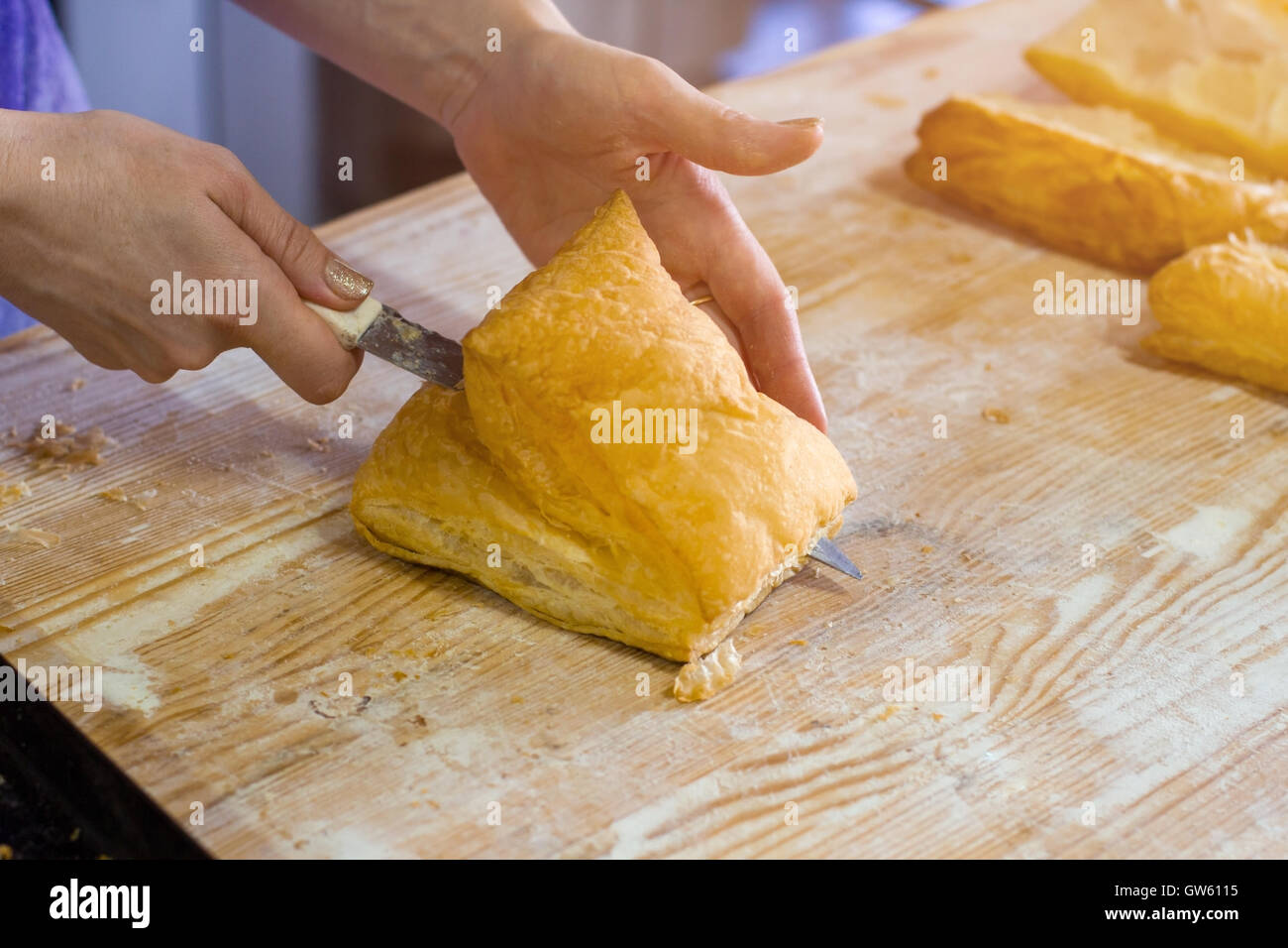 Hand with knife cutting pastry Stock Photo - Alamy