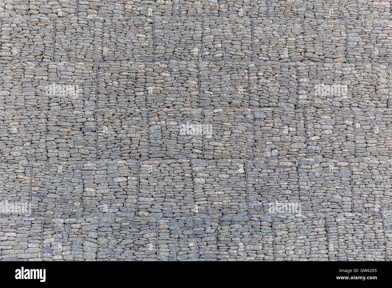 The wall of river stones packed in a metal grid Stock Photo - Alamy