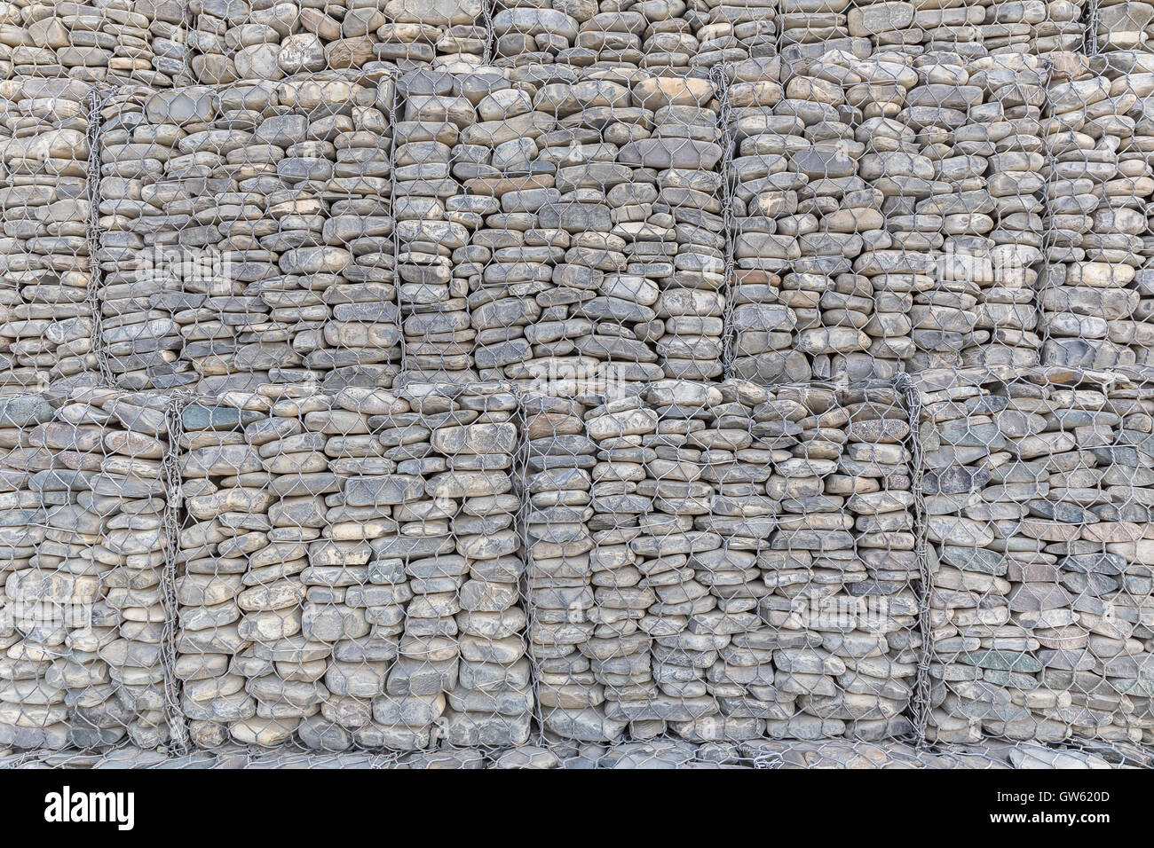 The wall of river stones packed in a metal grid Stock Photo - Alamy