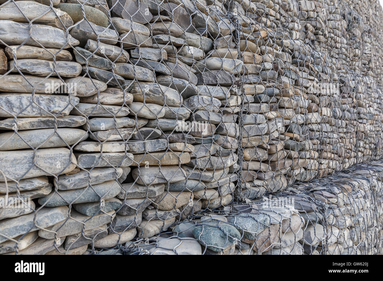 The wall of river stones packed in a metal grid Stock Photo - Alamy