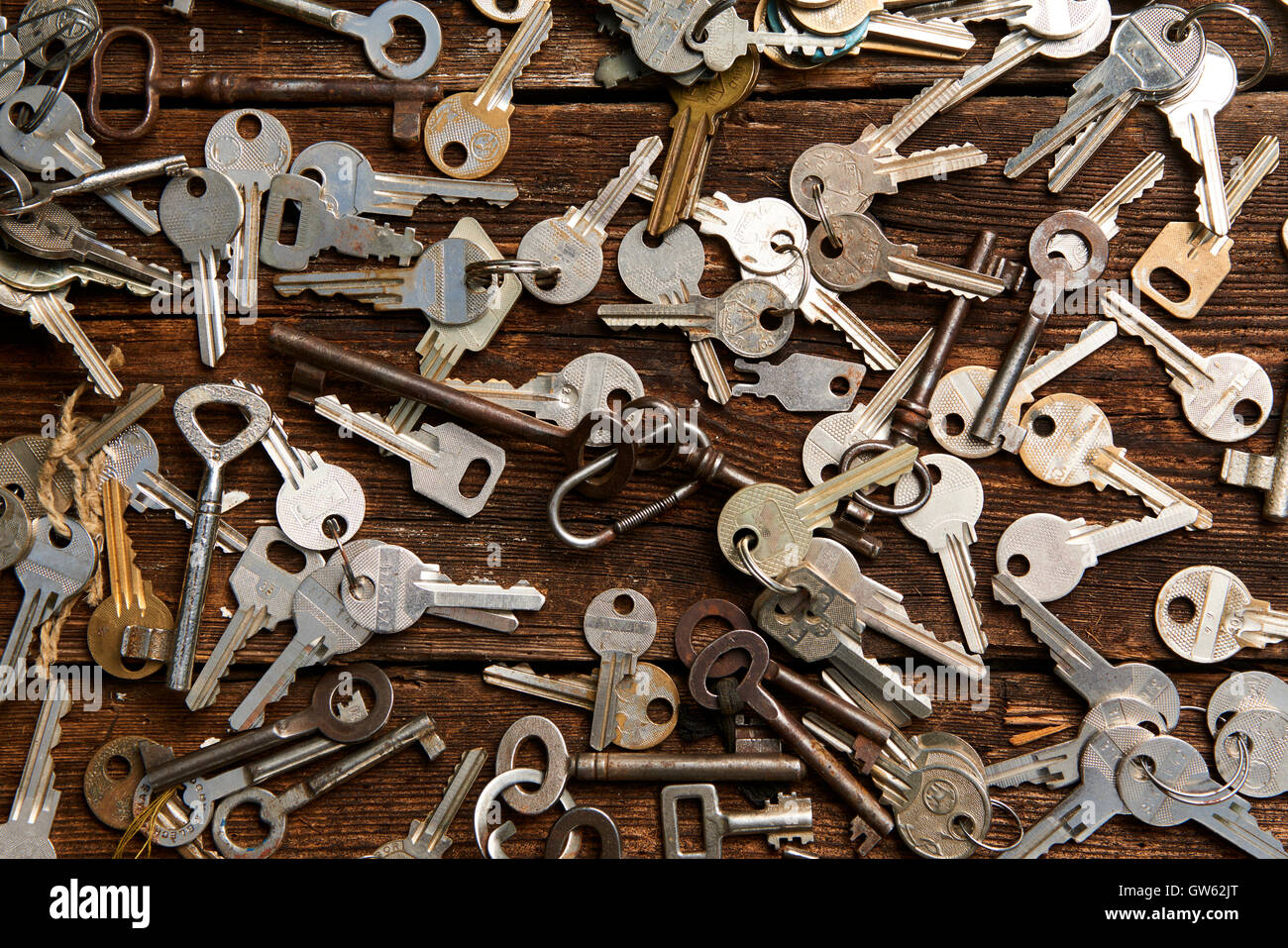 Pile of keys on a grunge wooden background Stock Photo - Alamy
