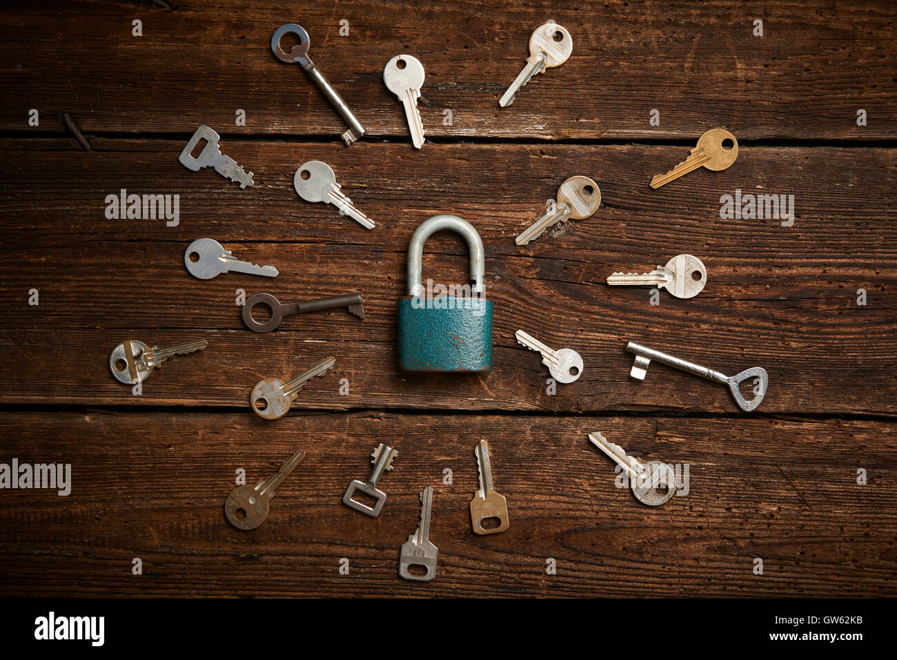 A lot of metal keys and a steel lock on a wooden boards Stock Photo - Alamy