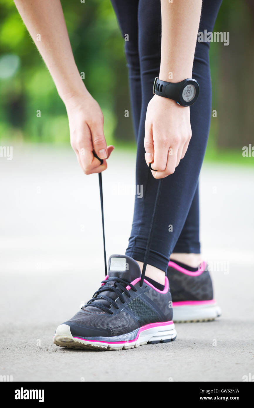 Shot of a young woman tying her laces before a run Stock Photo - Alamy