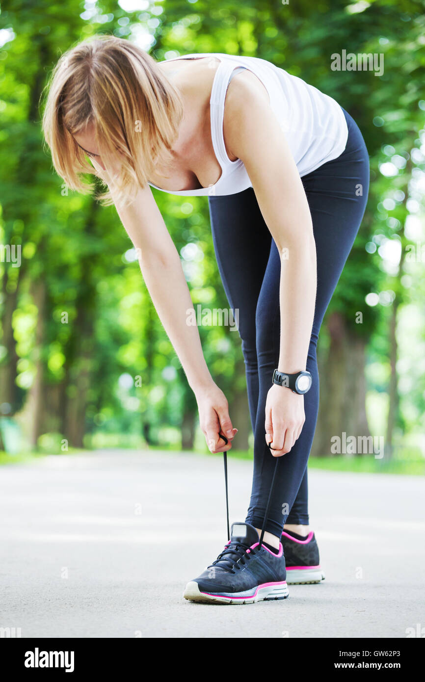 Woman tying her shoes hi-res stock photography and images - Alamy