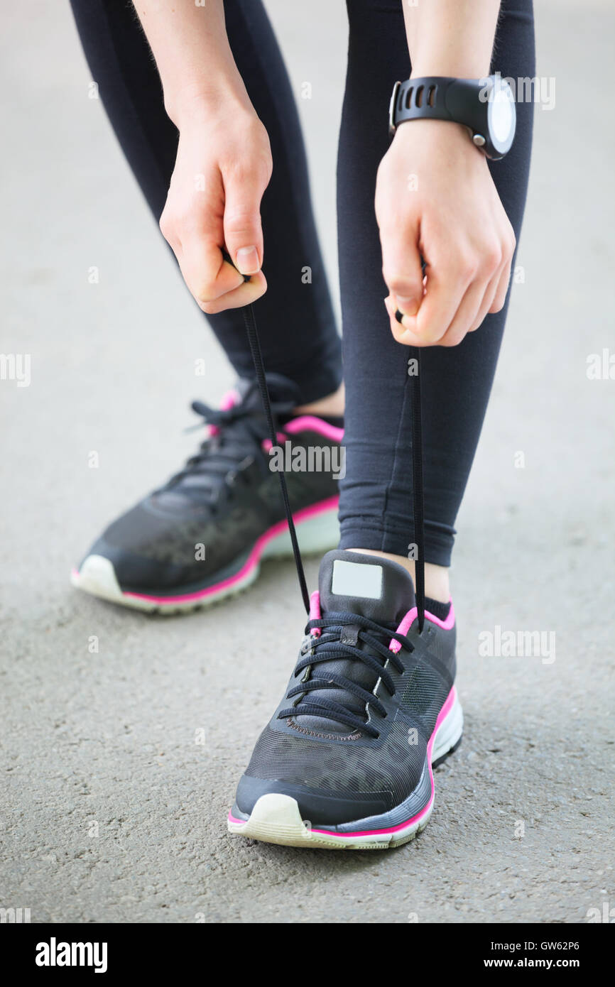 Shot of a young woman tying her laces before a run Stock Photo - Alamy
