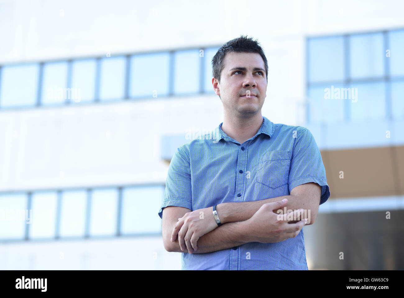 Man standing in front of an office building Stock Photo - Alamy