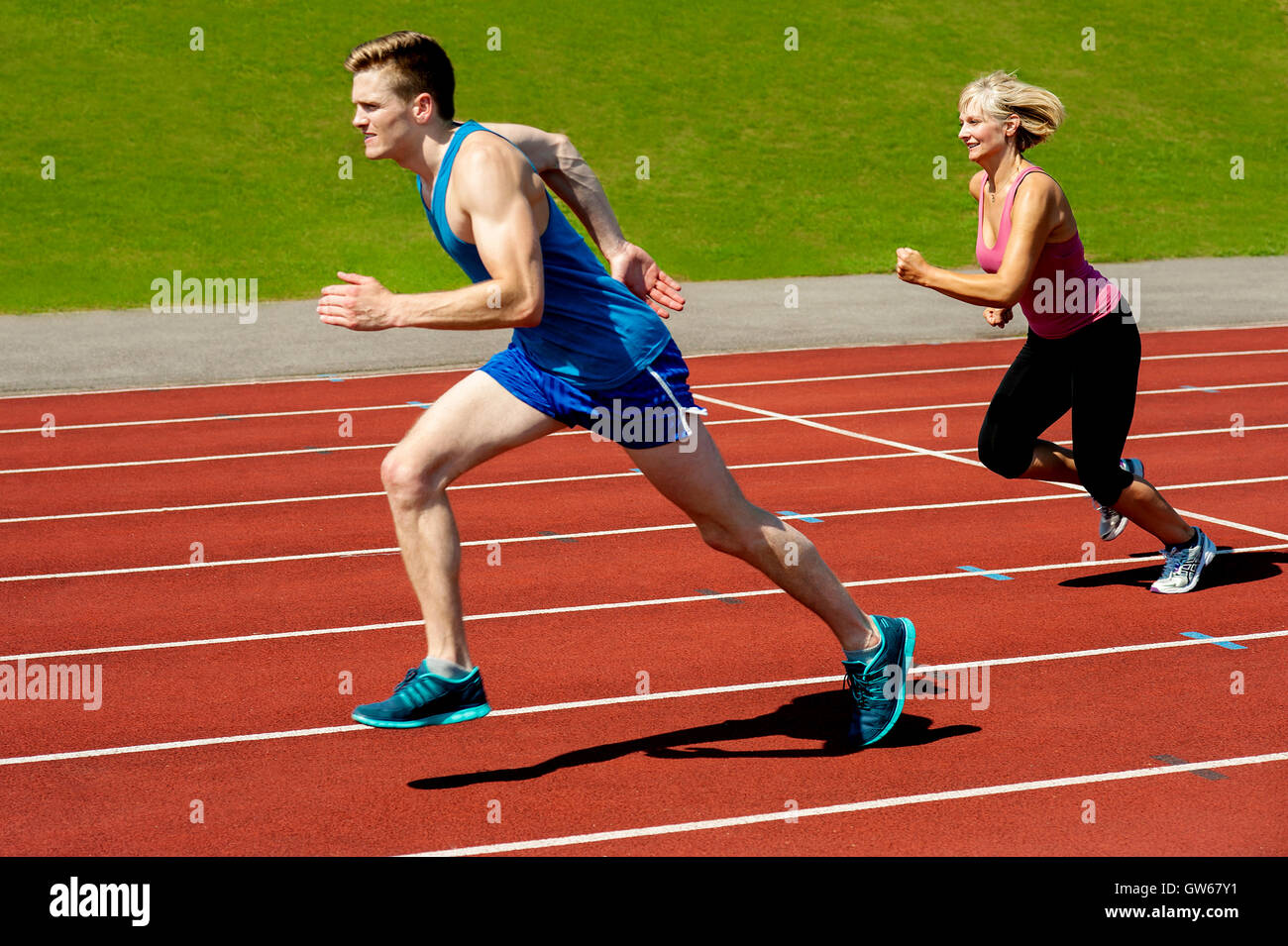 Athletes running on race track Stock Photo - Alamy