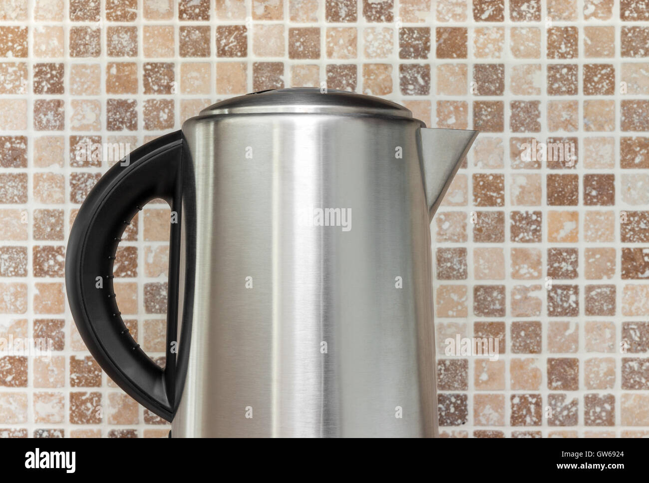 Electric kettle on kitchen tile background Stock Photo - Alamy