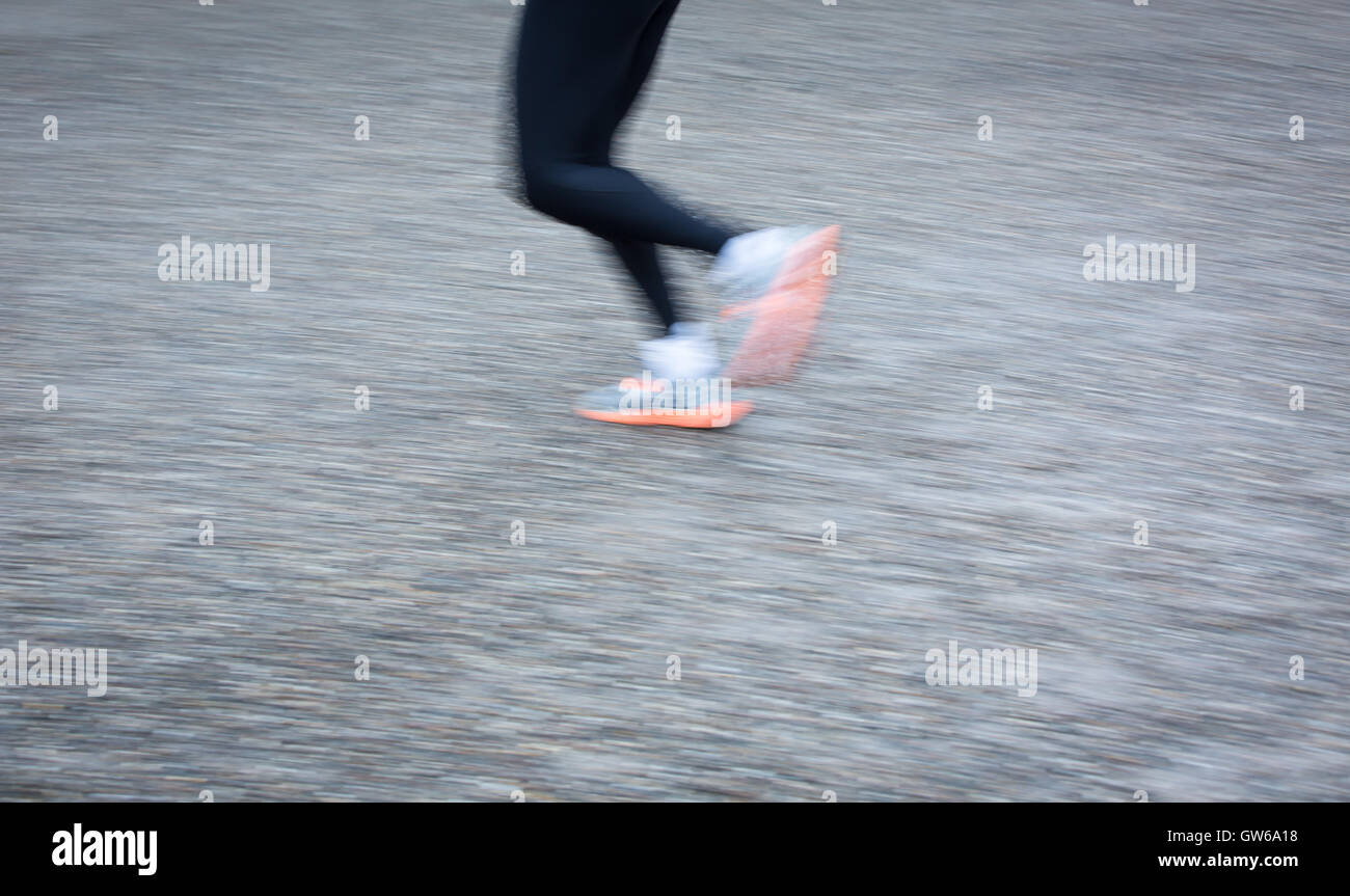 Motion blurred runner's feet in a city environment (panning tech Stock ...