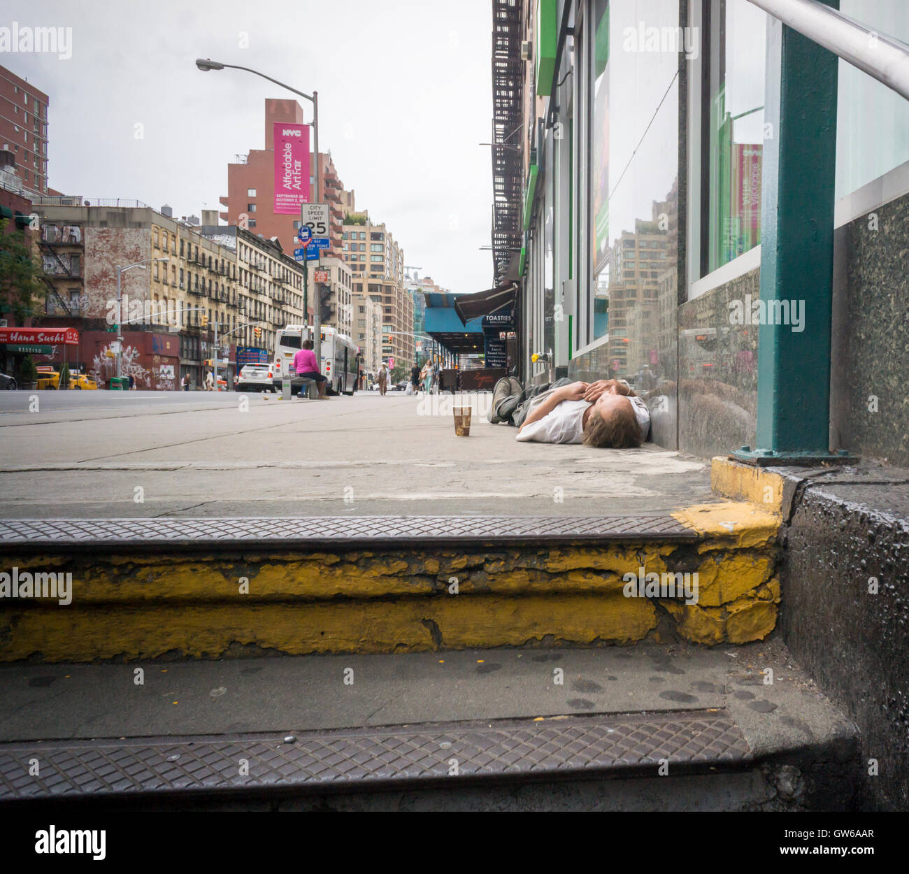 A homeless individual sleeps outside a subway station in New York on ...