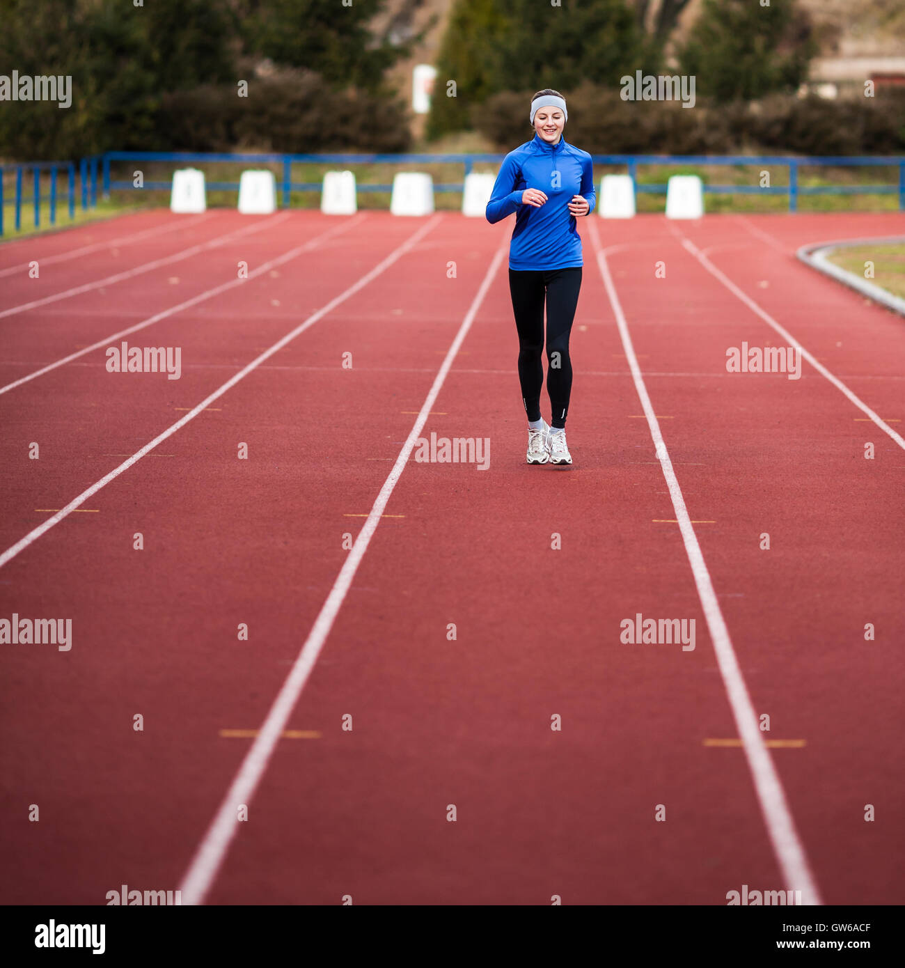 Young woman running at a track and field stadium Stock Photo - Alamy