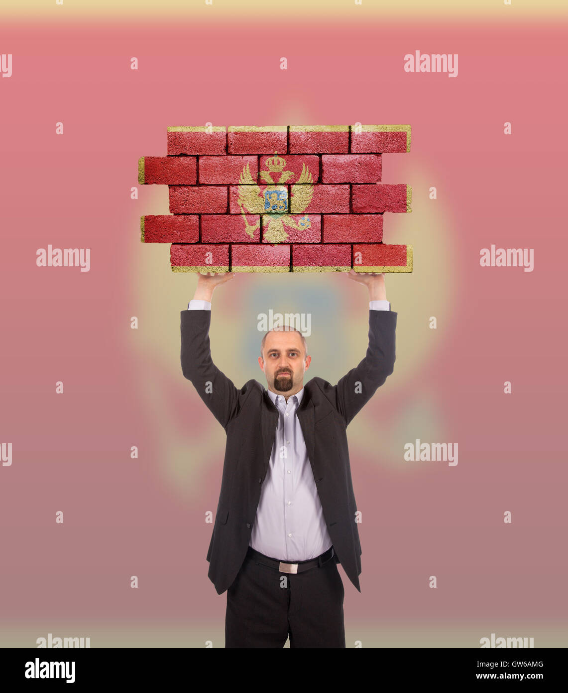 Businessman holding a large piece of a brick wall Stock Photo - Alamy