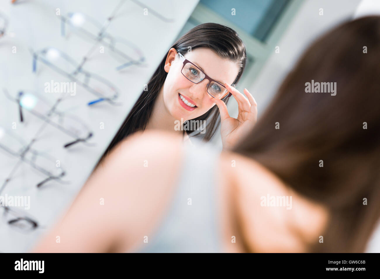 Pretty, young woman choosing new glasses frames in an optician s Stock ...