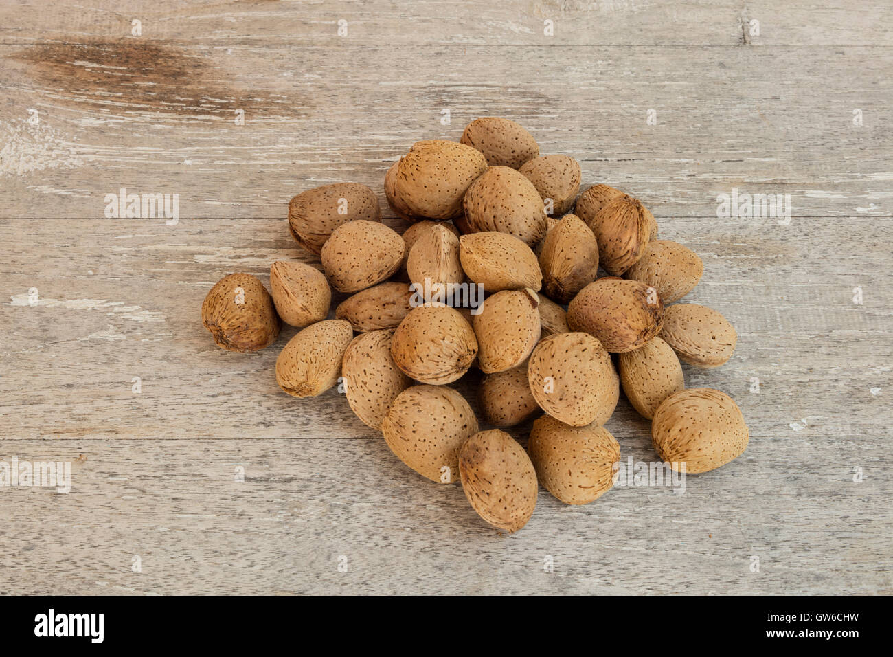 Group of almonds on a brown wooden table Stock Photo - Alamy