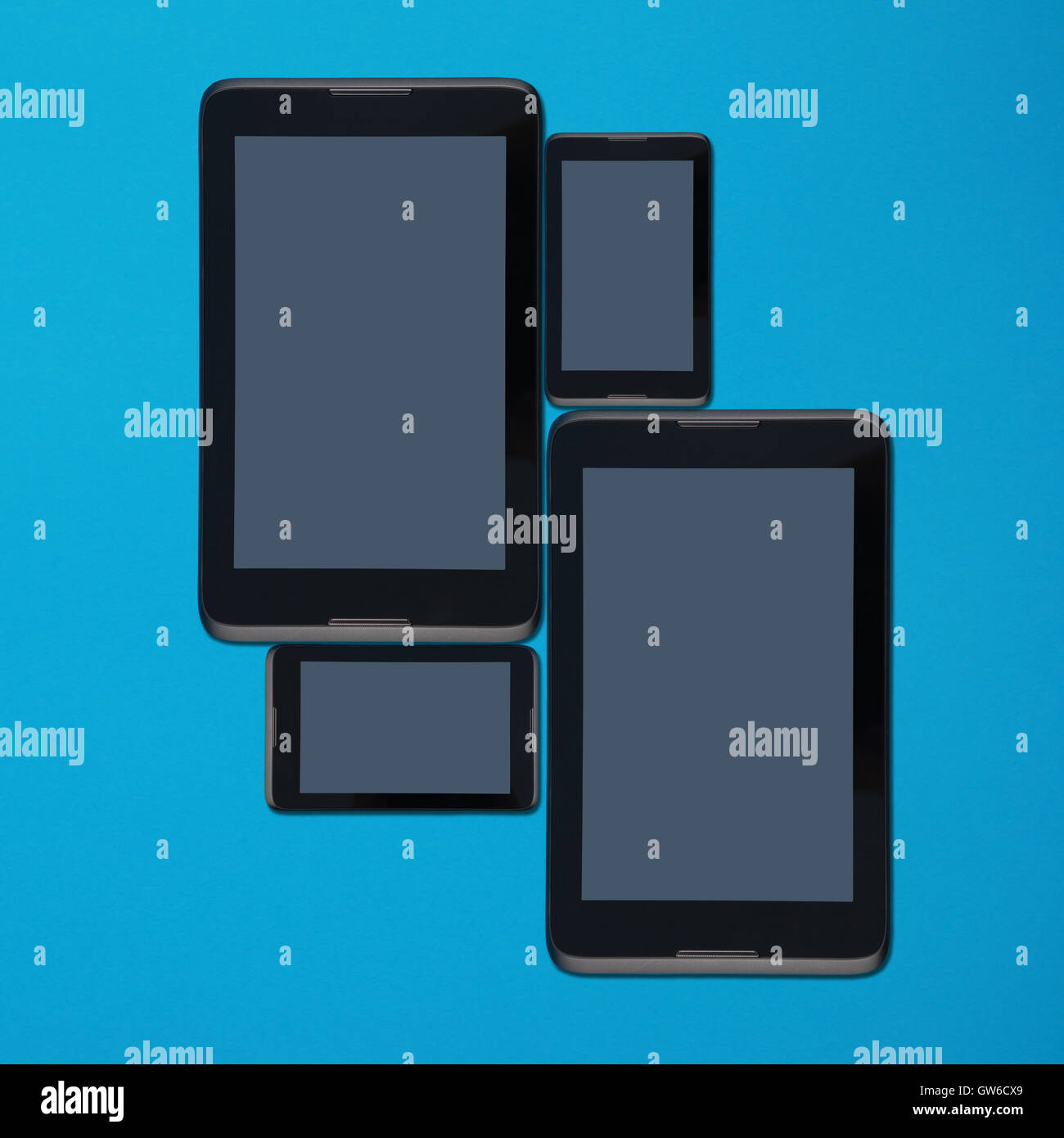 Tablet pc and smartphone lying side by side isolated on blue background ...