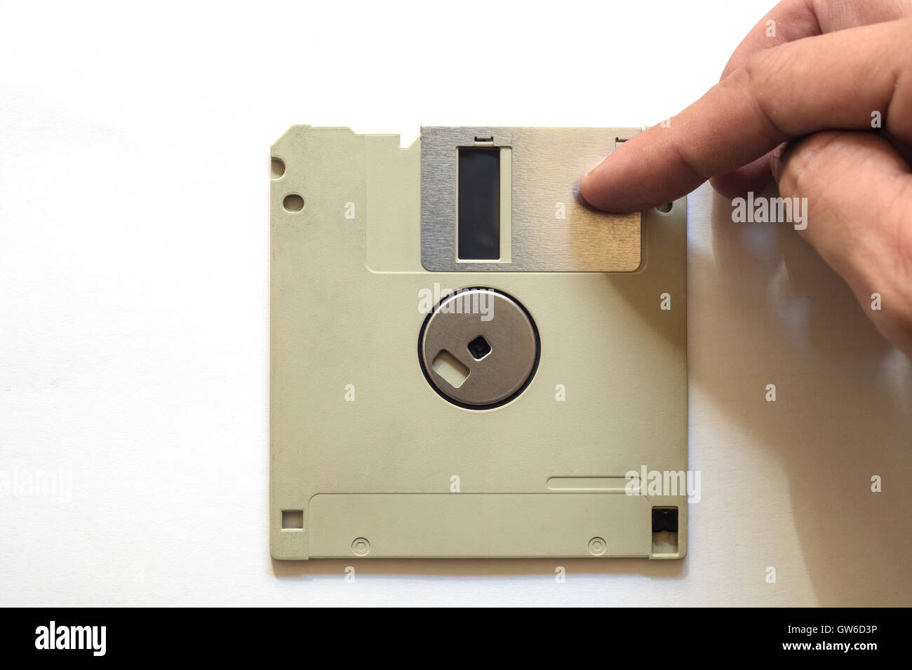 Detail of floppy disc on a white isolated background. A hand moves the ...