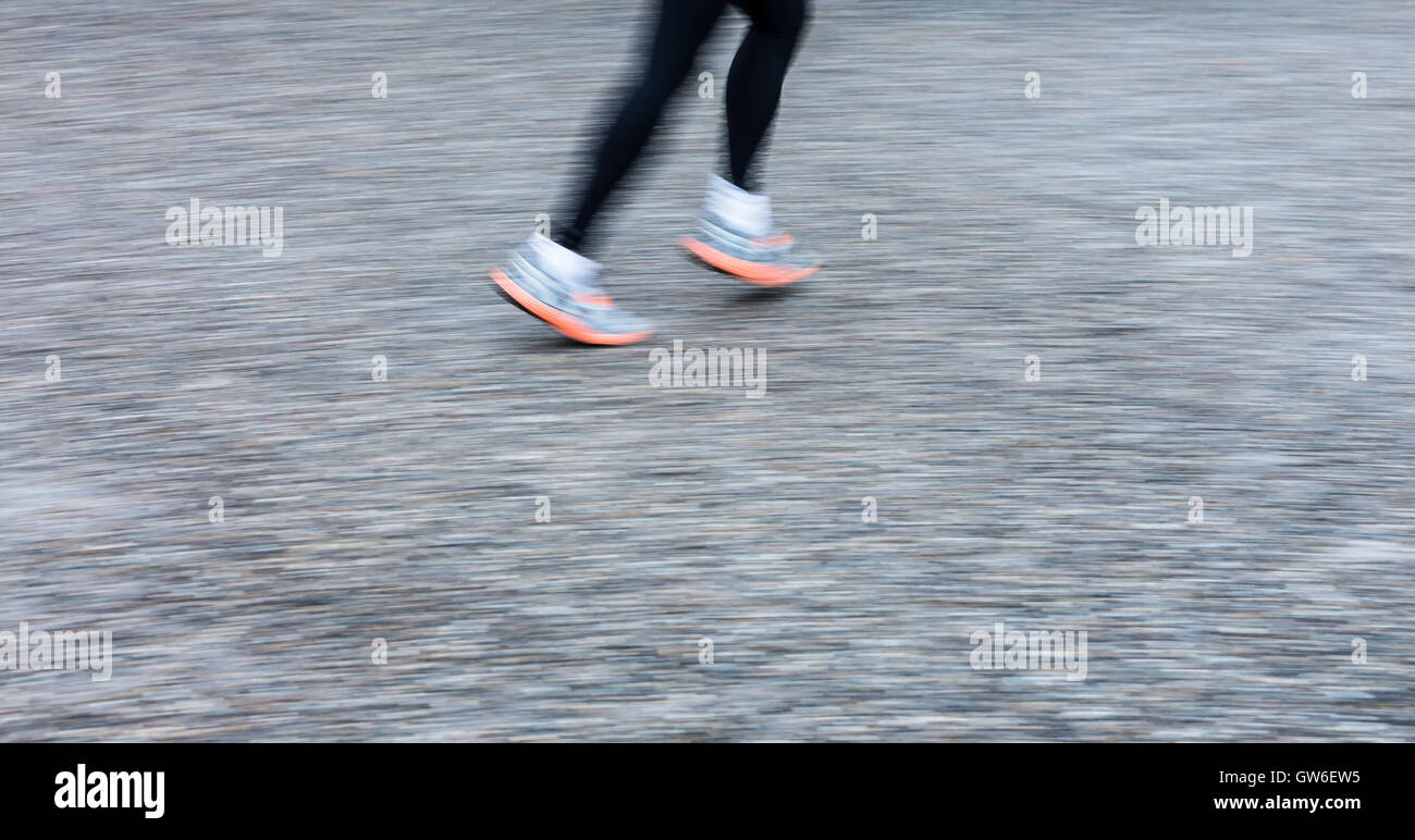 Motion blurred runner's feet in a city environment (panning tech Stock ...