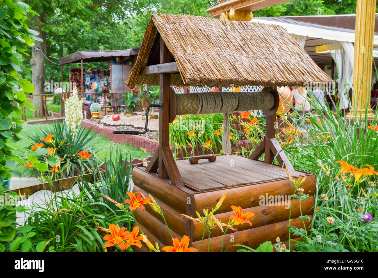 A wooden well with a thatched roof Stock Photo - Alamy