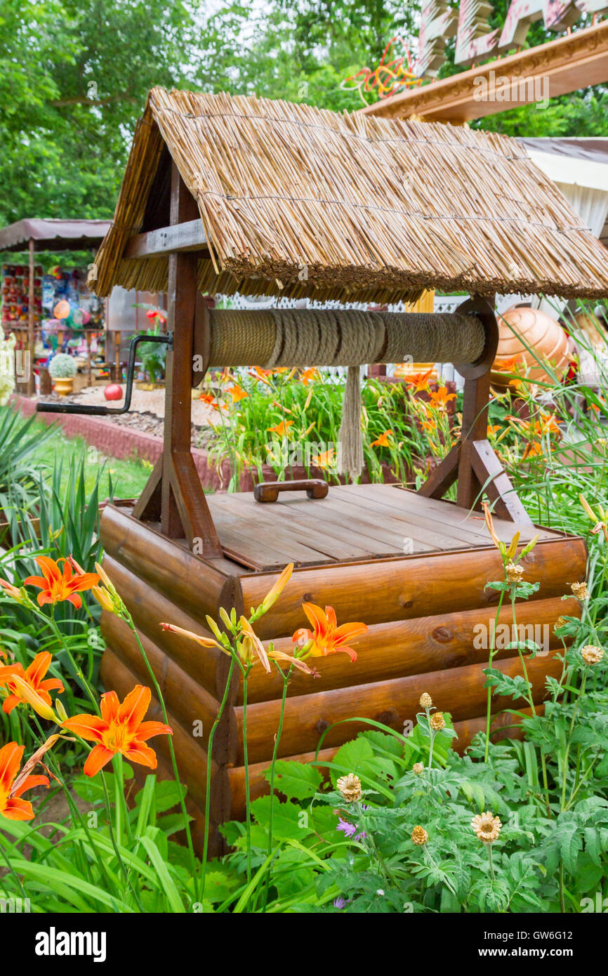 A wooden well with a thatched roof Stock Photo - Alamy