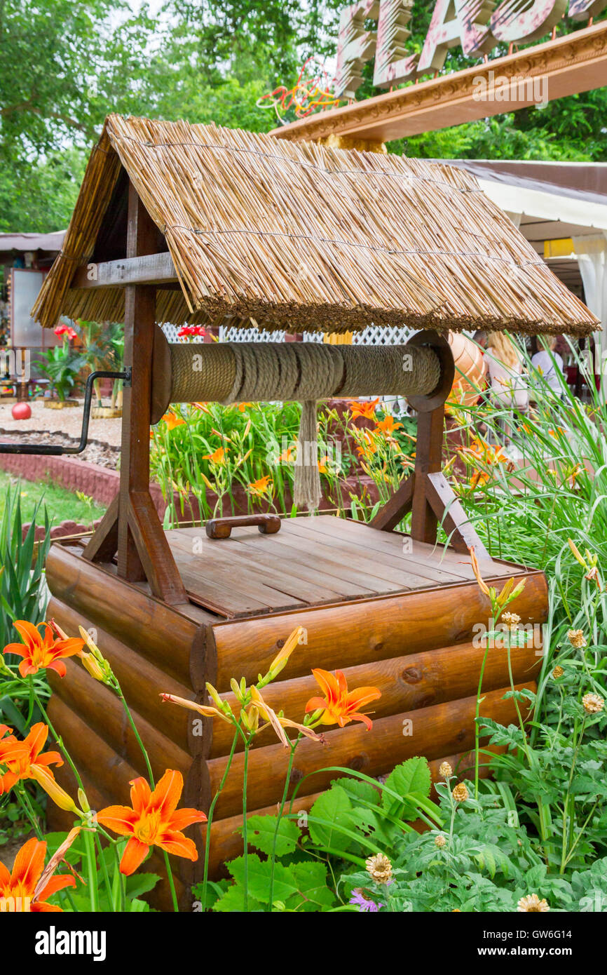 A wooden well with a thatched roof Stock Photo - Alamy