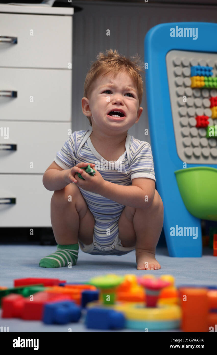 A baby boy crying in children's room Stock Photo - Alamy