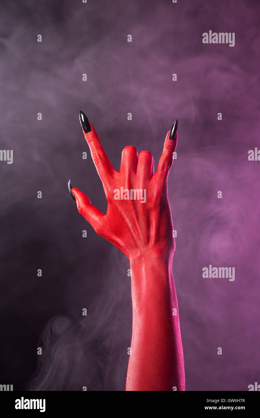 Heavy metal gesture, red devil hand with black nails Stock Photo - Alamy