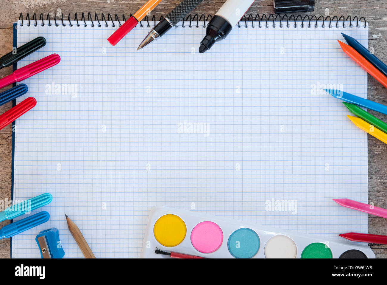 Banded notebook on a wooden table with copyspace with several elements ...