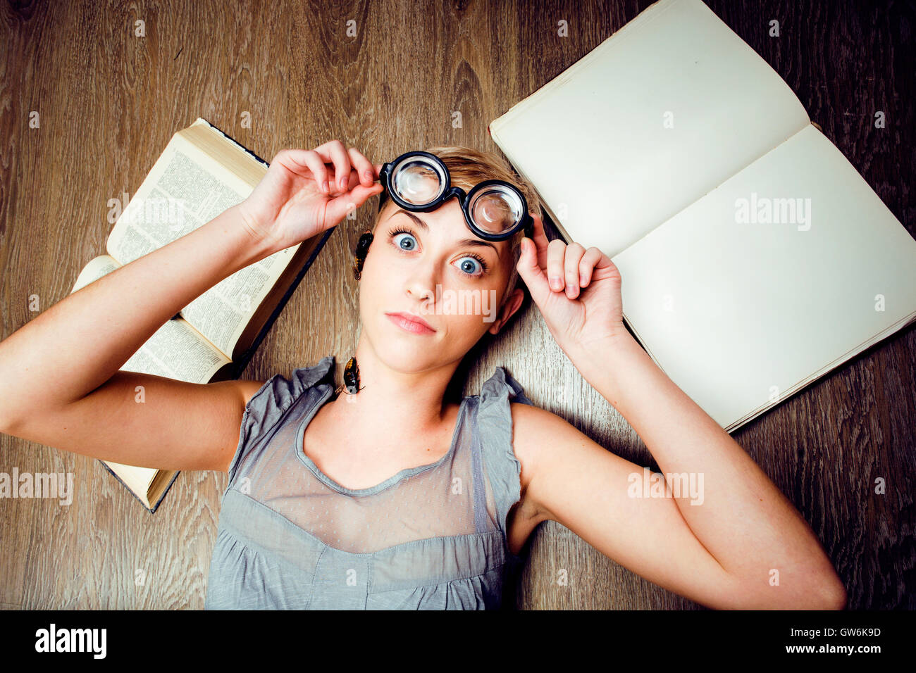 portrait of crazy student girl in glasses with books and cockroaches ...