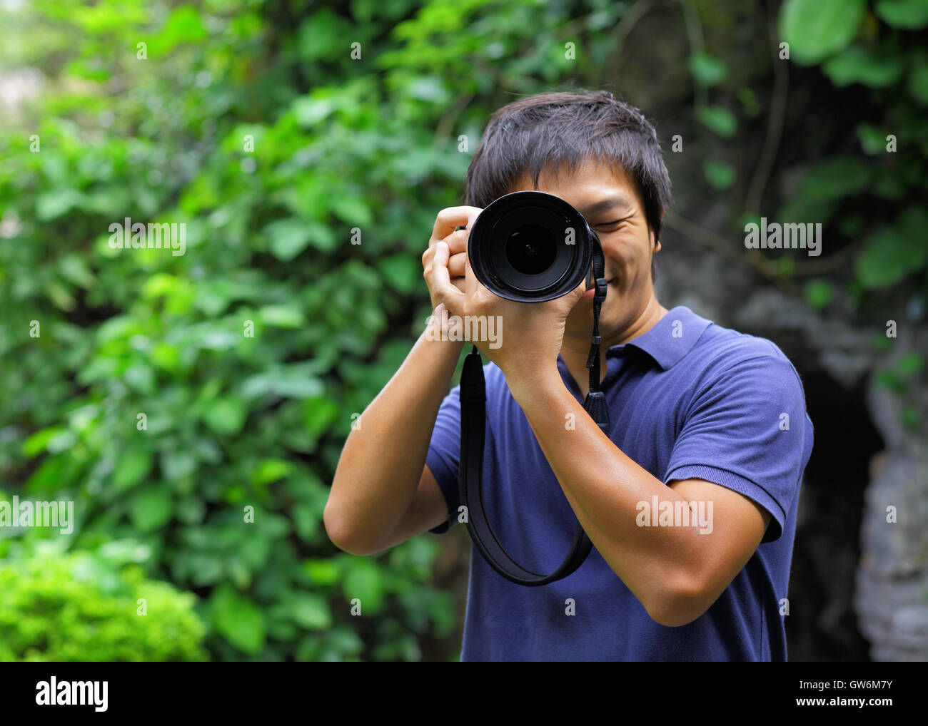 Asian man taking photo Stock Photo - Alamy