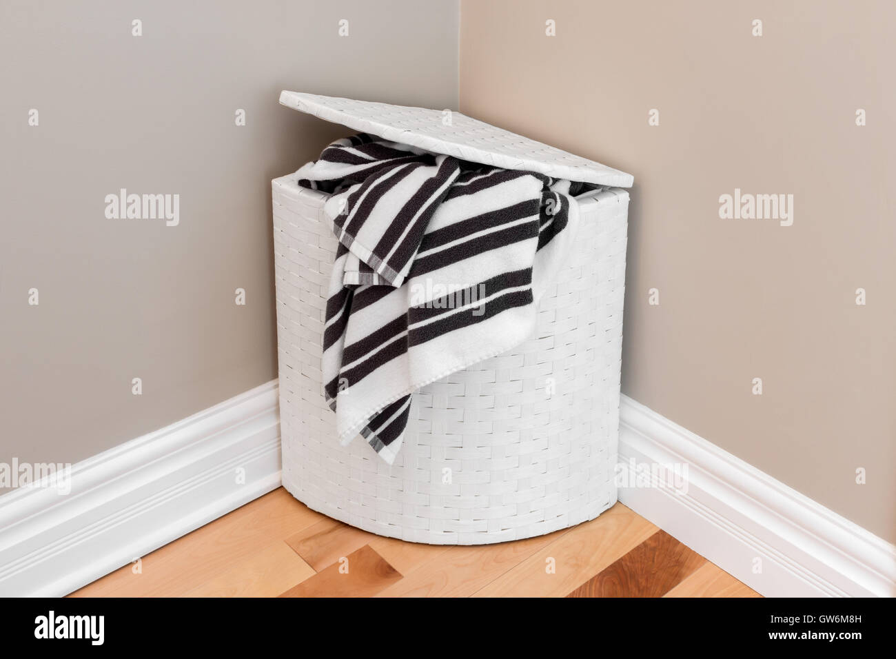 Laundry basket in the room corner Stock Photo - Alamy