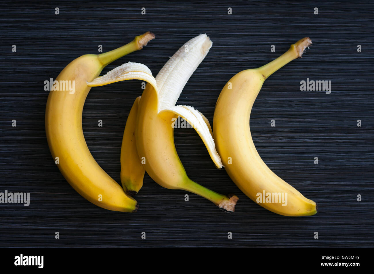 three ripe bananas are laid out in a number of average opened the half ...