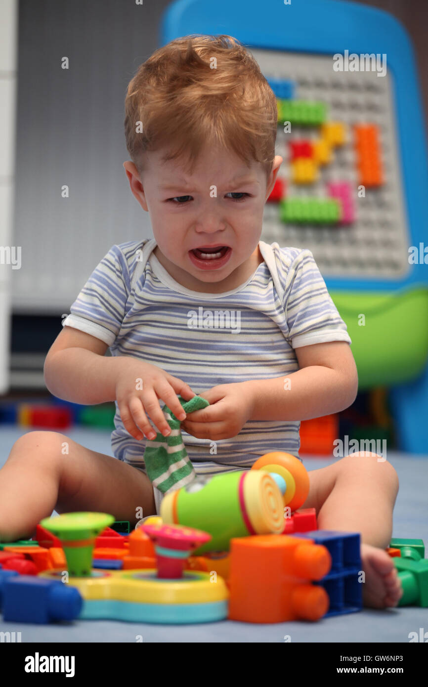 A baby boy crying in children's room Stock Photo - Alamy