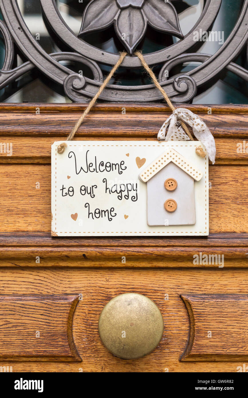 Closeup of a small shield attached to a wooden door reading: Welcome to ...