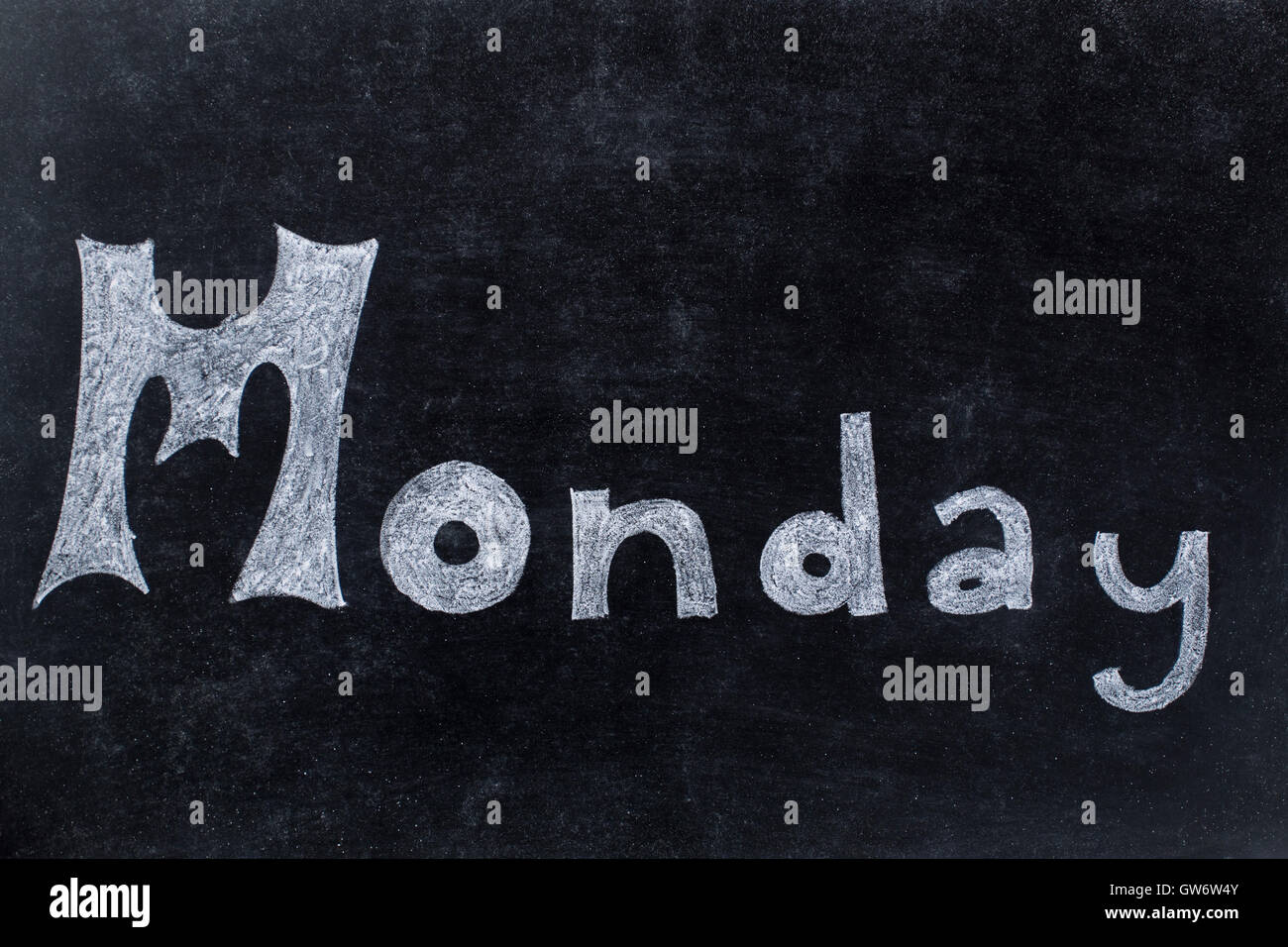 Monday written on white on black chalkboard background Stock Photo - Alamy