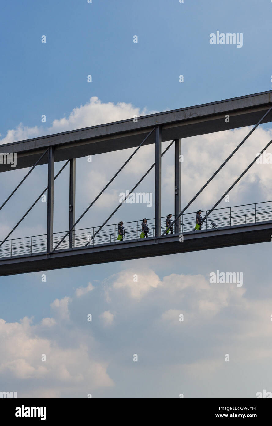 woman walking over modern bridge, cloud sky background Stock Photo - Alamy