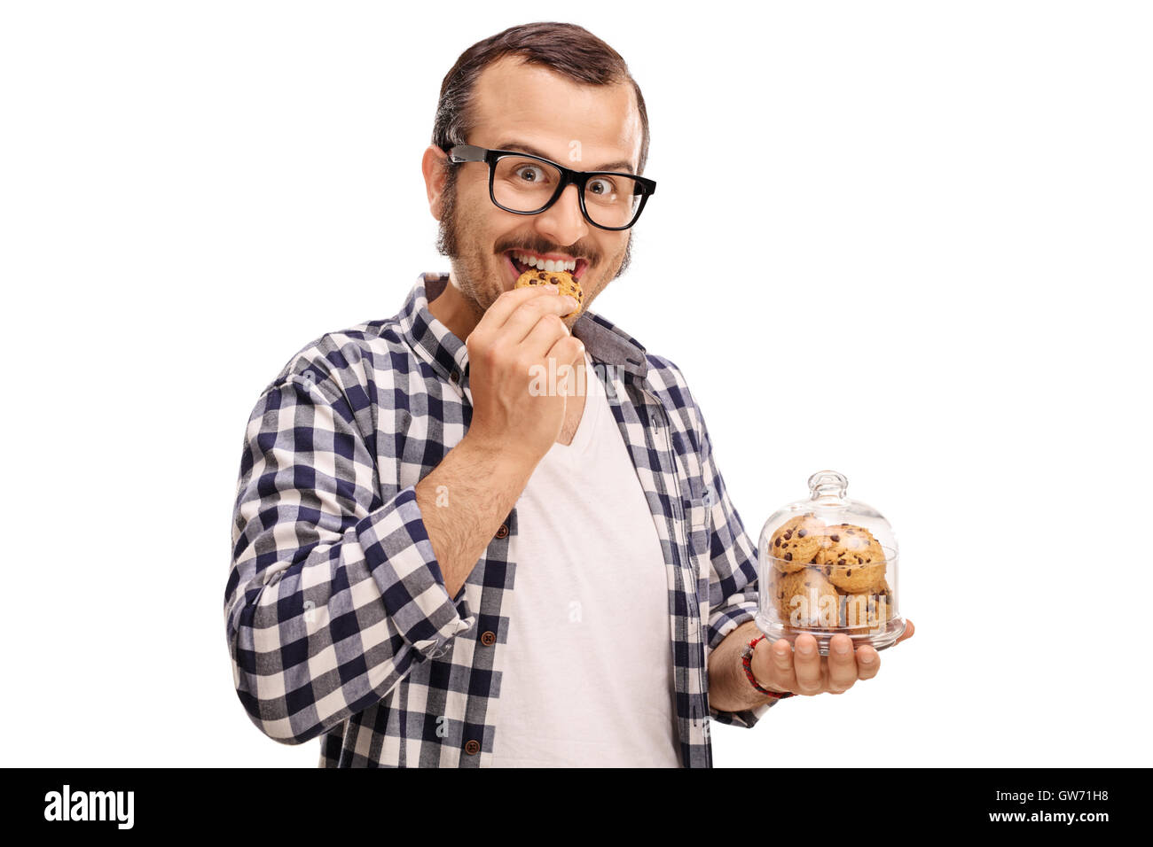 Smiling man eating a cookie and holding a jar full of cookies isolated ...