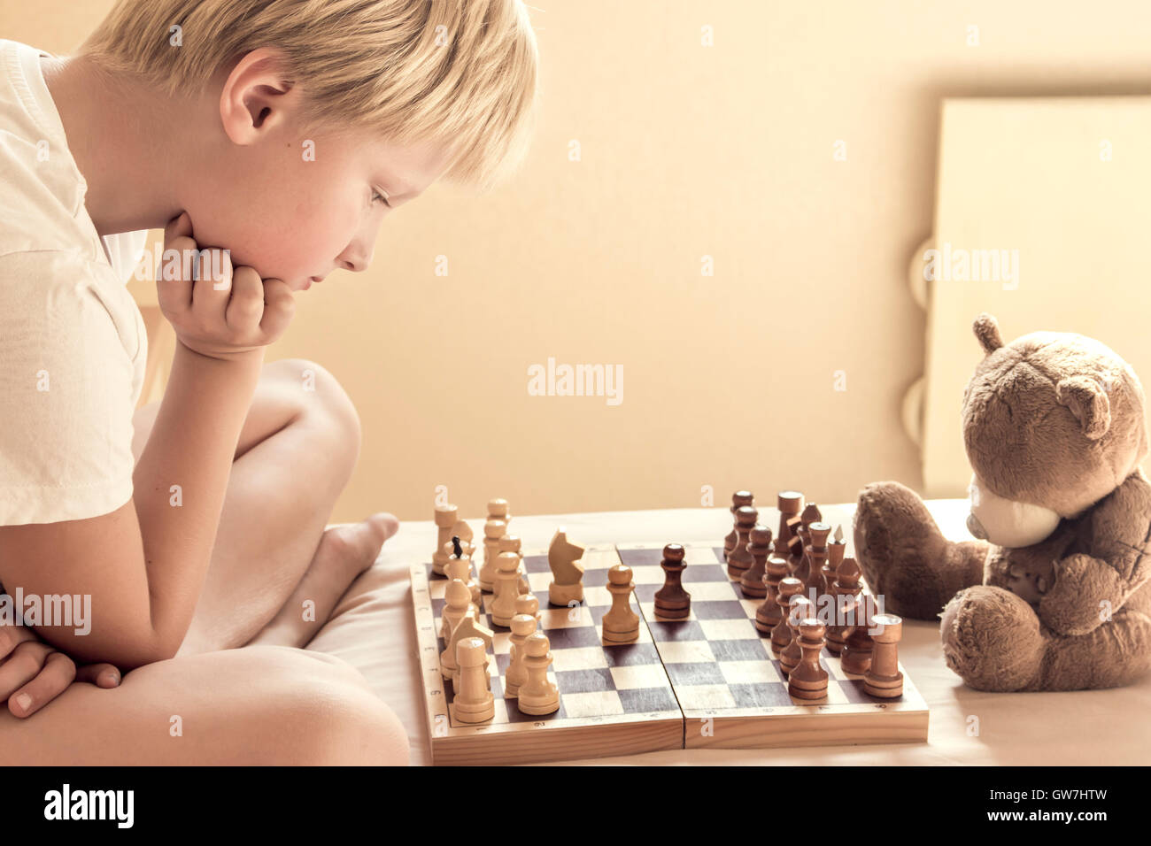 Child boy playing chess at home, intellectual game, tint and selective ...
