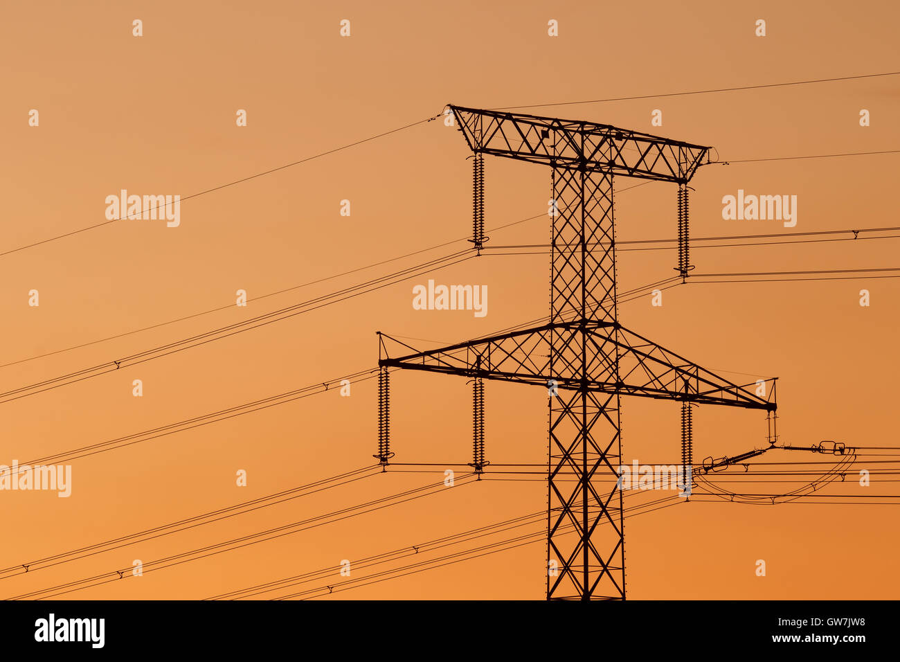 Silhouette of electricity pylon at golden sunset Stock Photo - Alamy